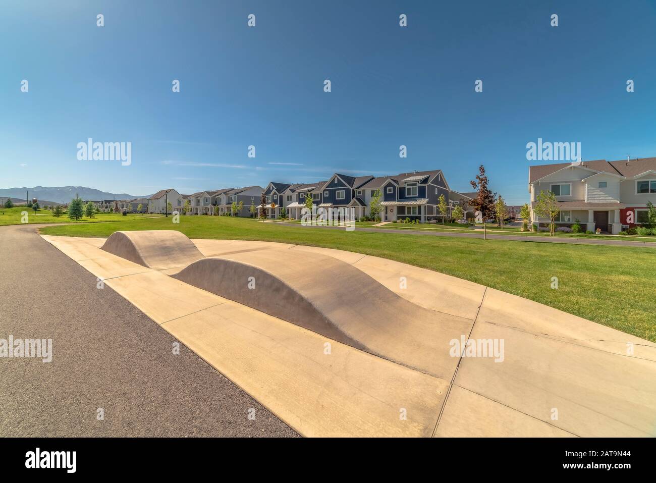 Ramp along a road and lawn in front of beautiful houses in the sunny ...