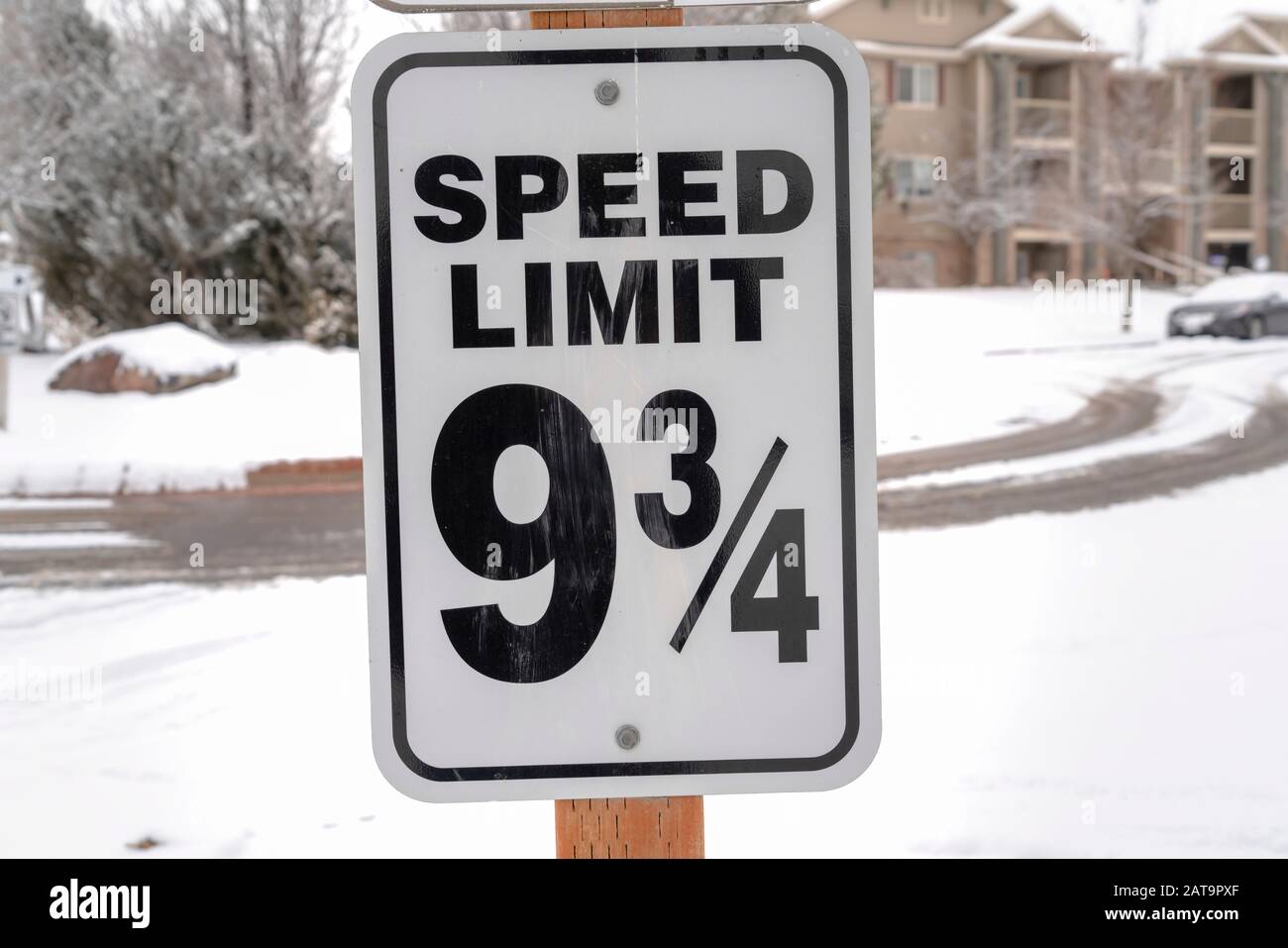 Speed Limit sign with road and snow covered ground in the blurry ...