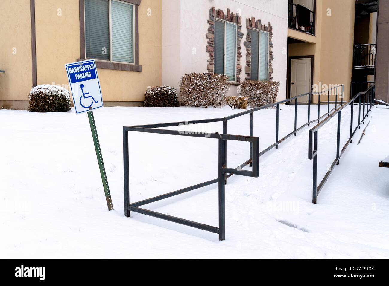 Handicapped Parking sign and wheelchair ramp at a snowy parking lot in ...