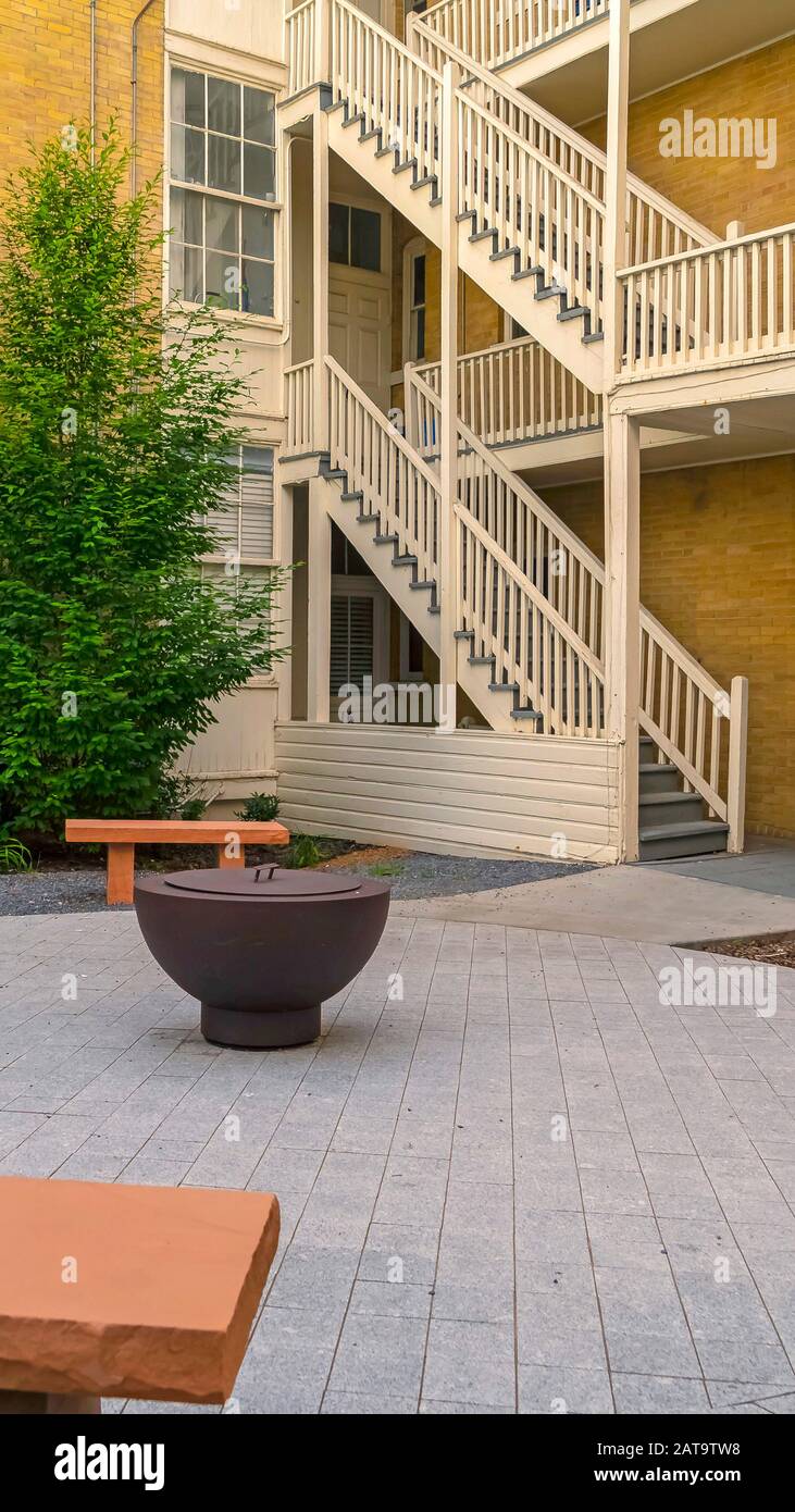 Vertical Fire pit on circular pavement with stone benches against ...