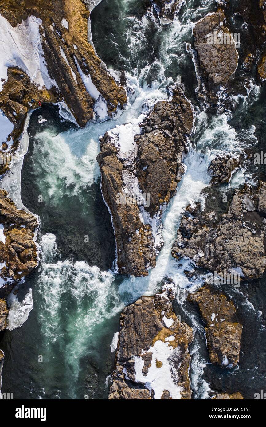 Aerial view of Godafoss waterfall, snowy shore and river. Iceland in ...