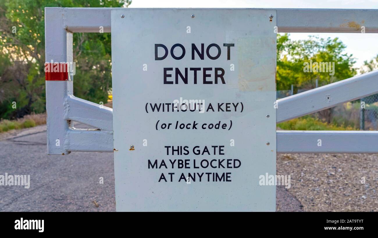 Panorama frame Do Not Enter sign mounted on a white gate against road ...