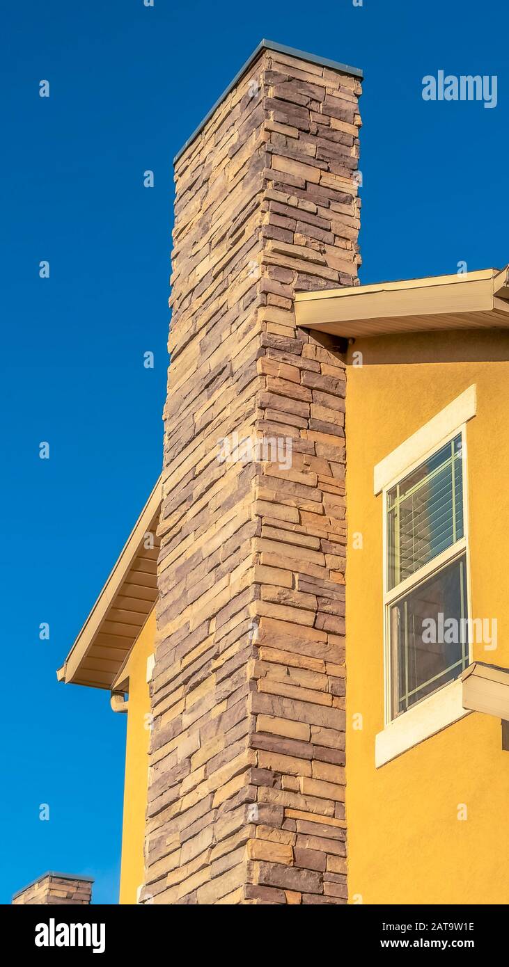 Vertical Home exterior with stone brick chimney against gable roof and ...