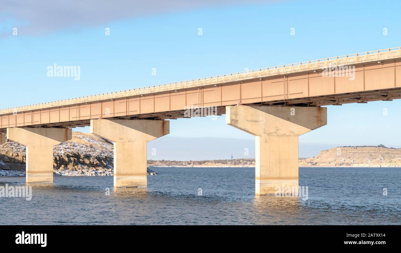 Panorama Stringer bridge crossing over a blue lake and connecting snowy ...