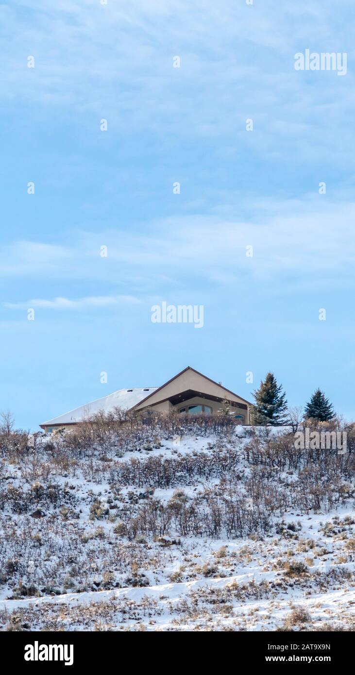 Vertical Hill top blanketed with white snow with view of gabled homes ...
