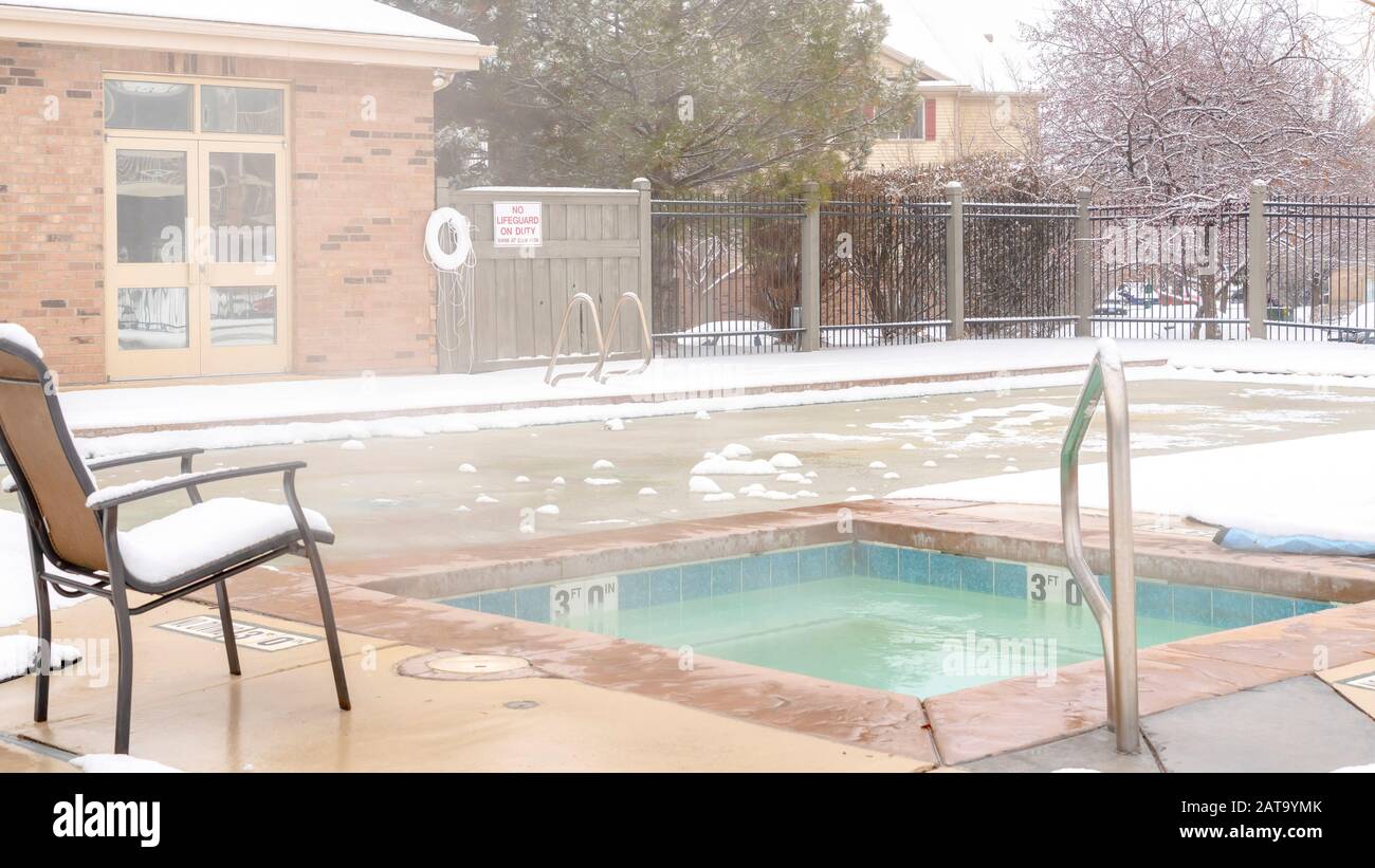 Panorama frame Frozen swimming pool area surrounded by snow on a foggy ...