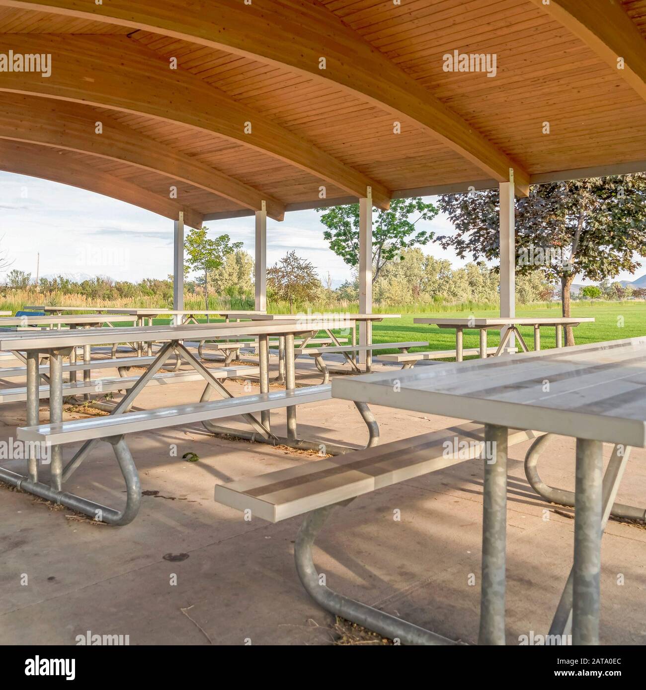 Square Eating area at a park with tables and seats under brown wood ...