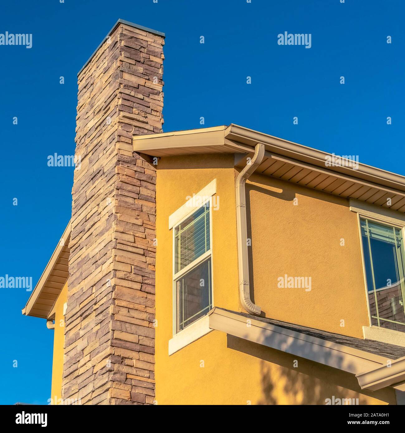 Square frame Home exterior with stone brick chimney against gable roof ...