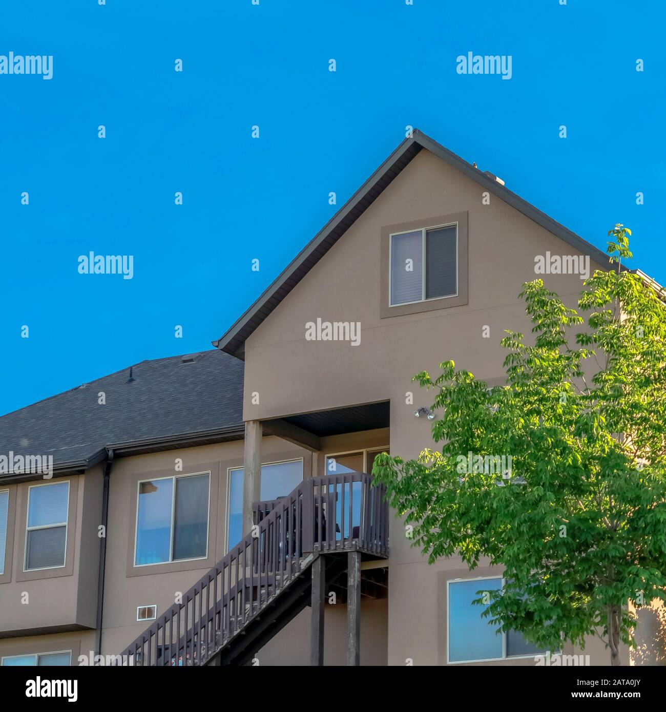 Square frame Home exterior with gable and valley roof against vibrant ...