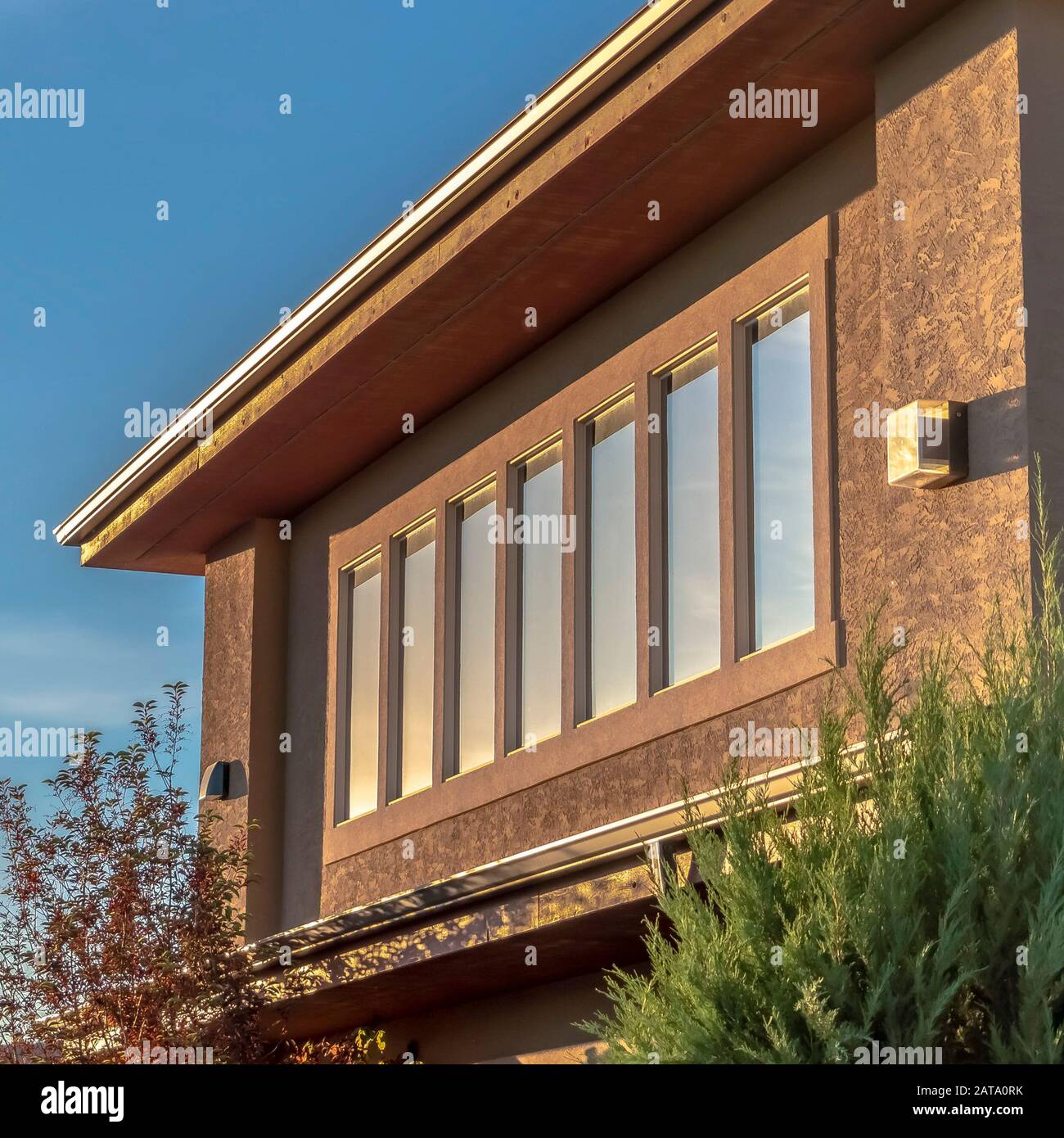 Square Sunlit house exterior with view of the upper storey against ...