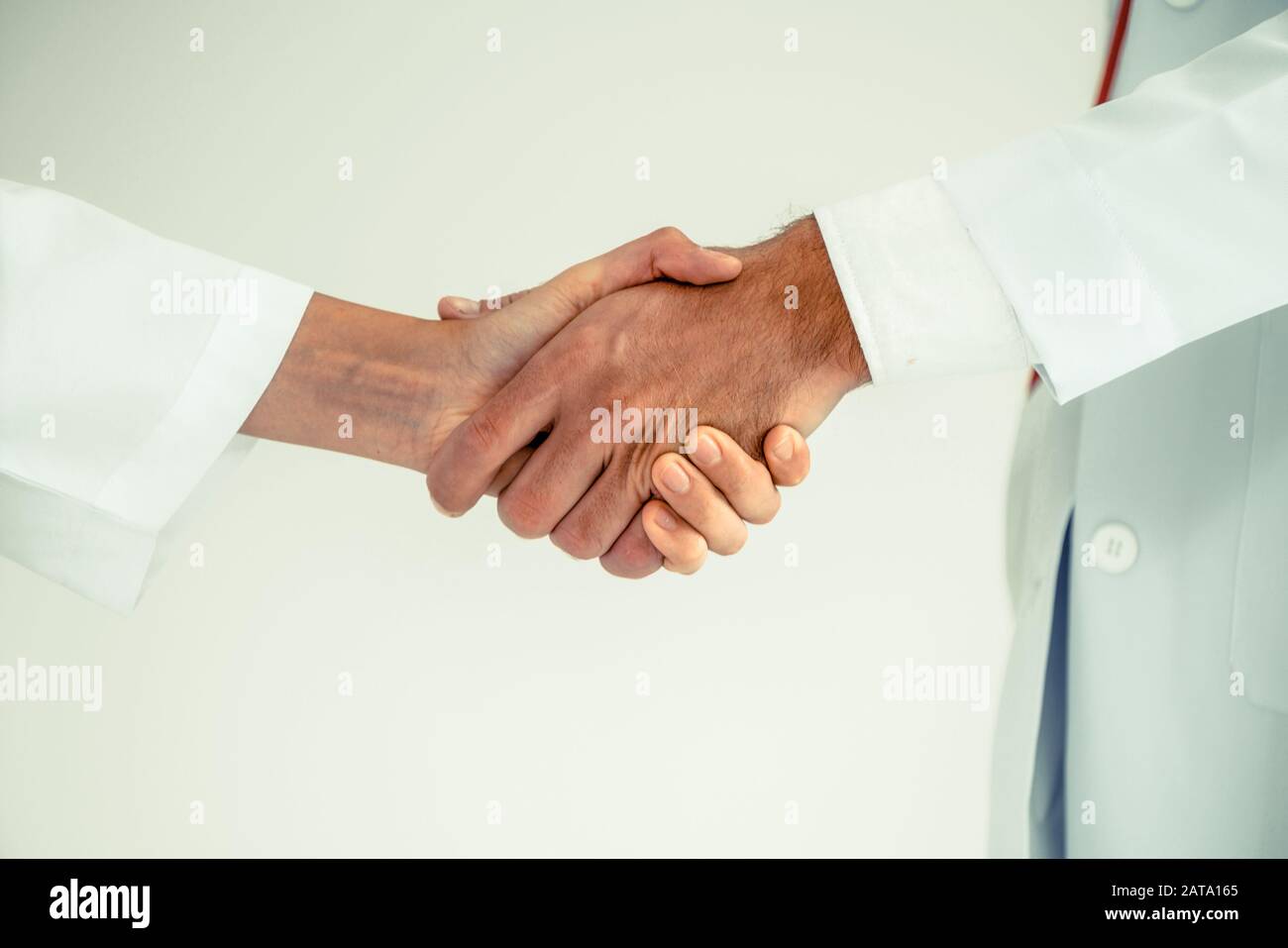 Doctor on white background giving handshake to another doctor showing ...