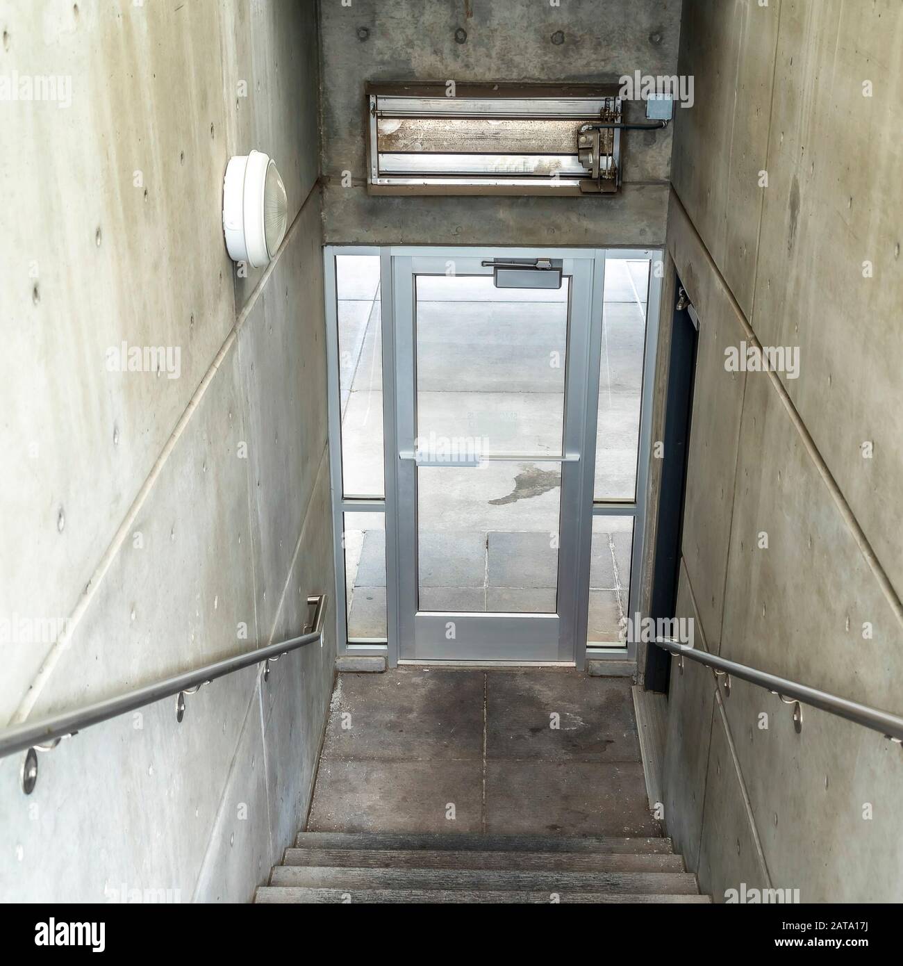 Square frame Staircase inside a building going down to a glass door ...