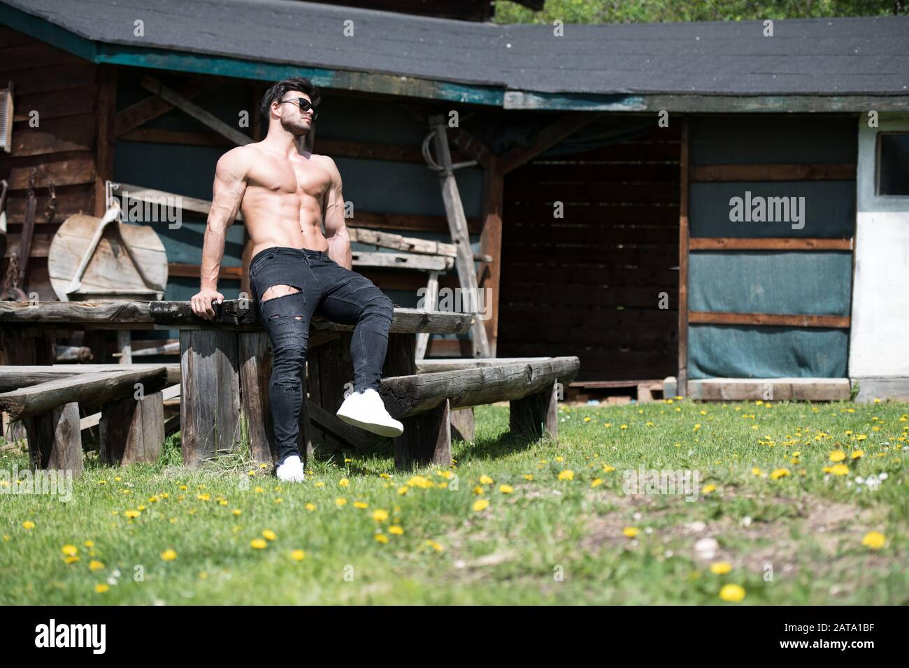 Healthy Young Man Sits Down Strong Flexing Muscles While Wearing Black ...