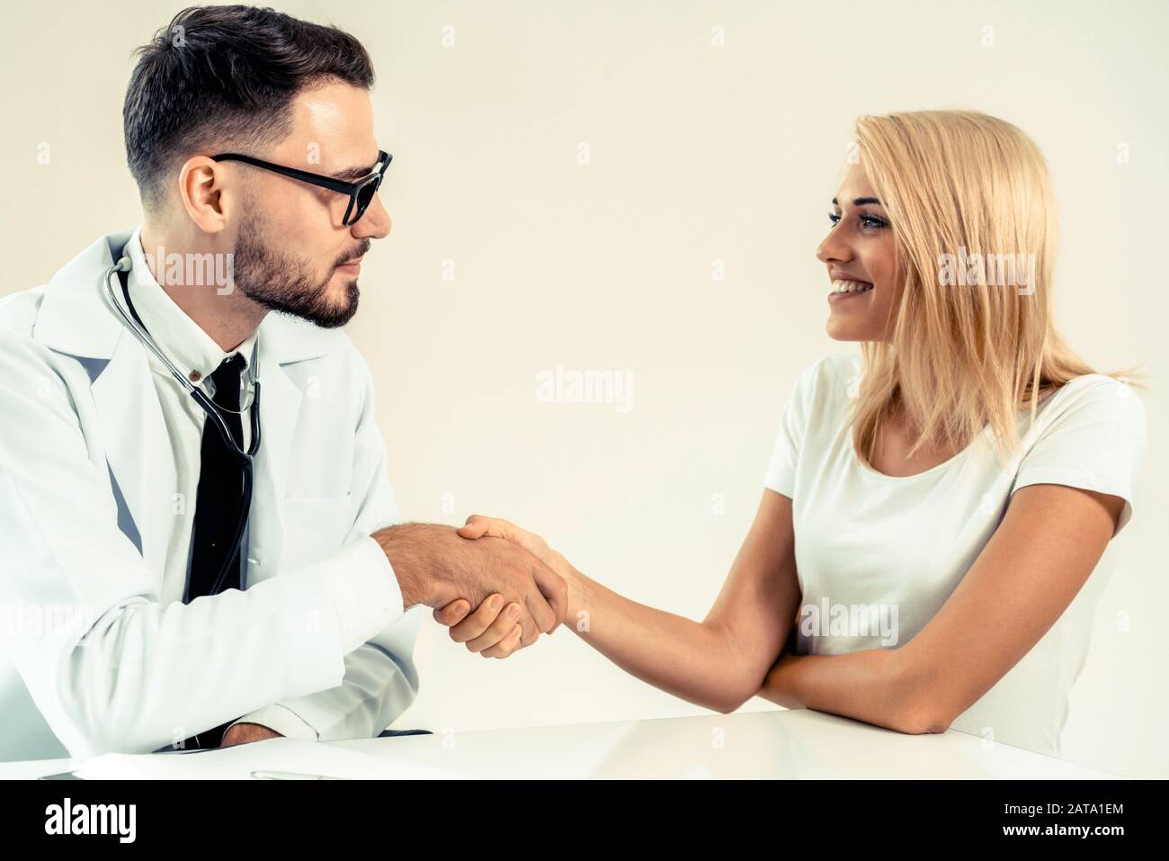 Male doctor doing handshake with female patient in hospital office ...