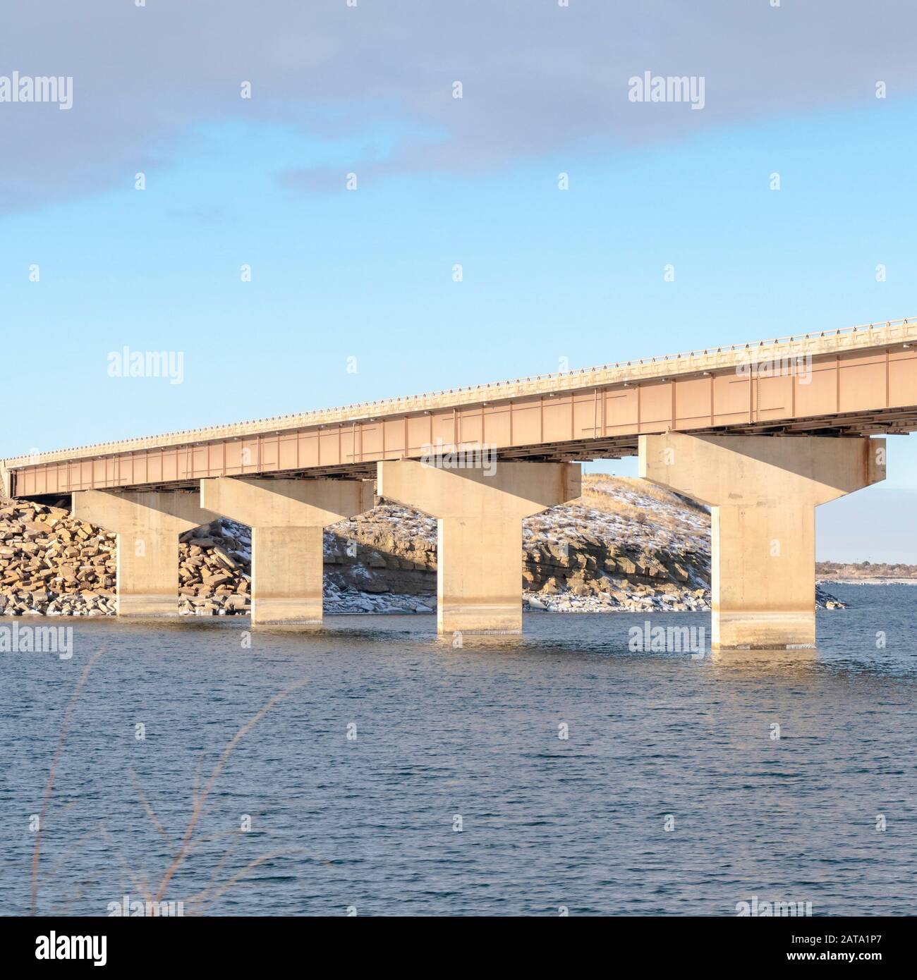 Square frame Stringer bridge crossing over a blue lake and connecting ...