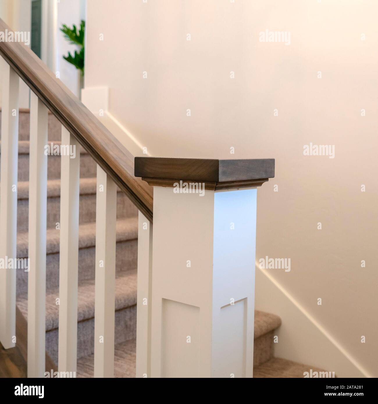 Square Indoor staircase of a home with white balusters brown handrail ...