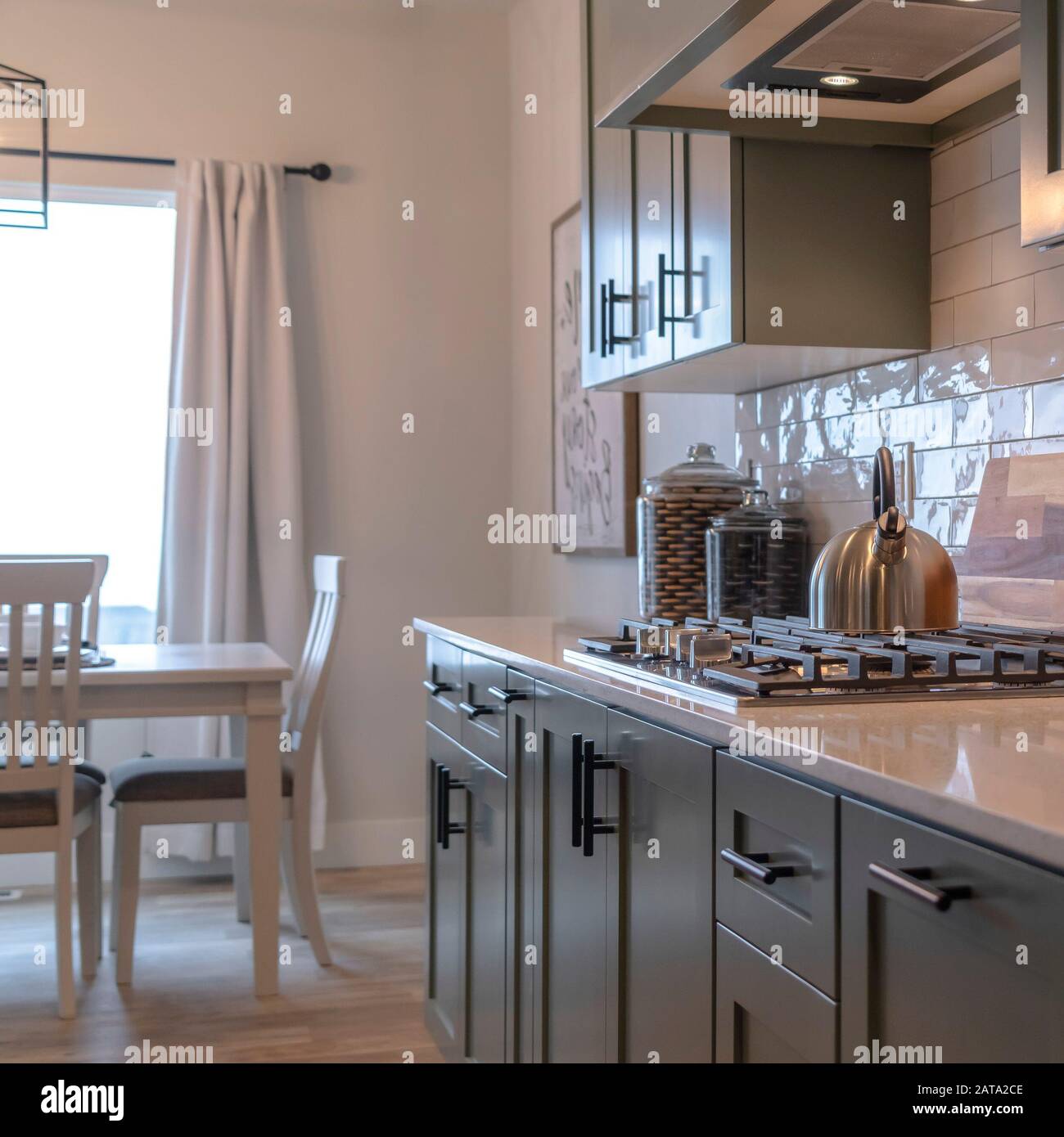 Square Kitchen work area with cabinets cooktop countertop and tile ...