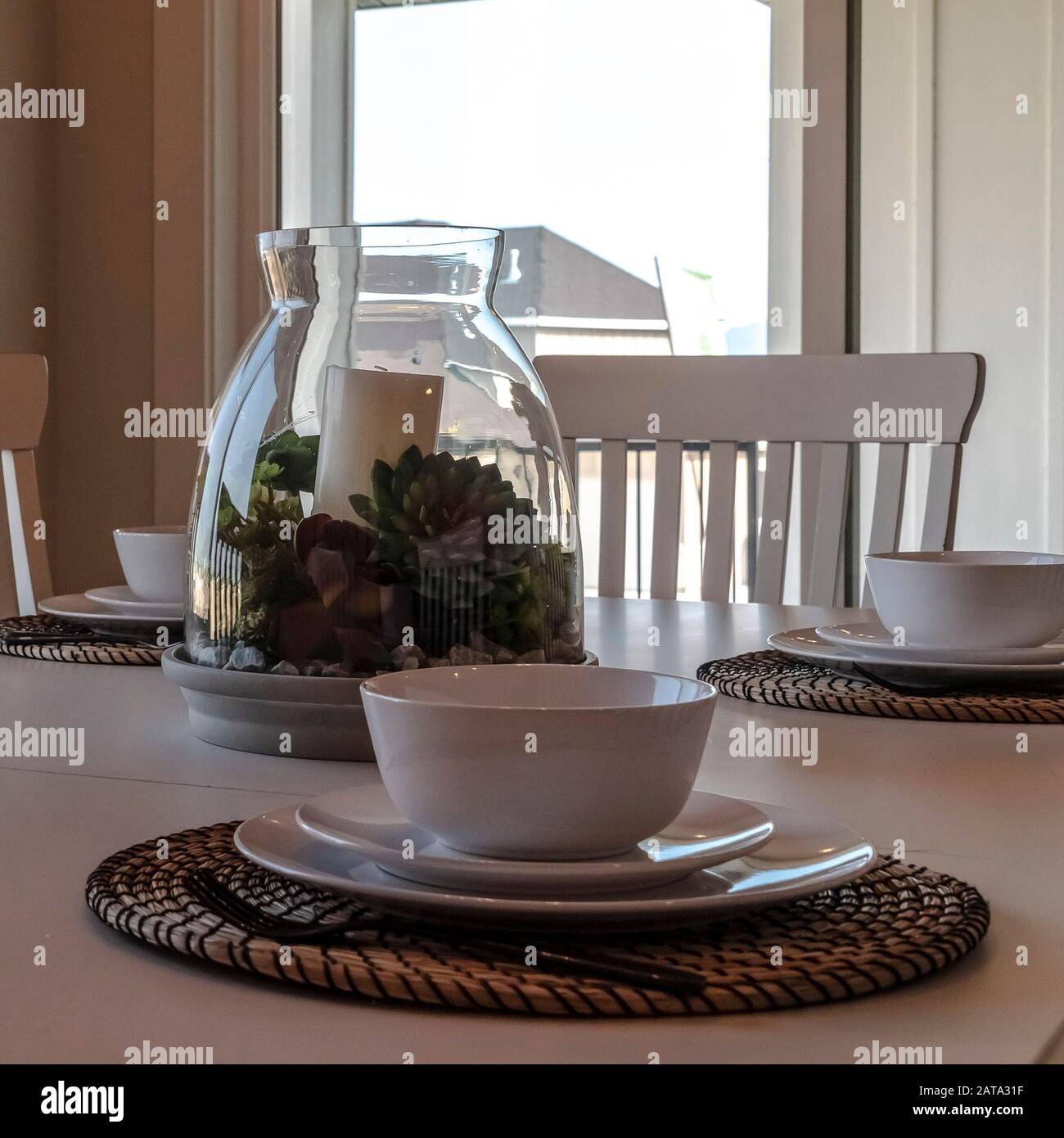 Photo Square Table setting at the dining room of home against window ...