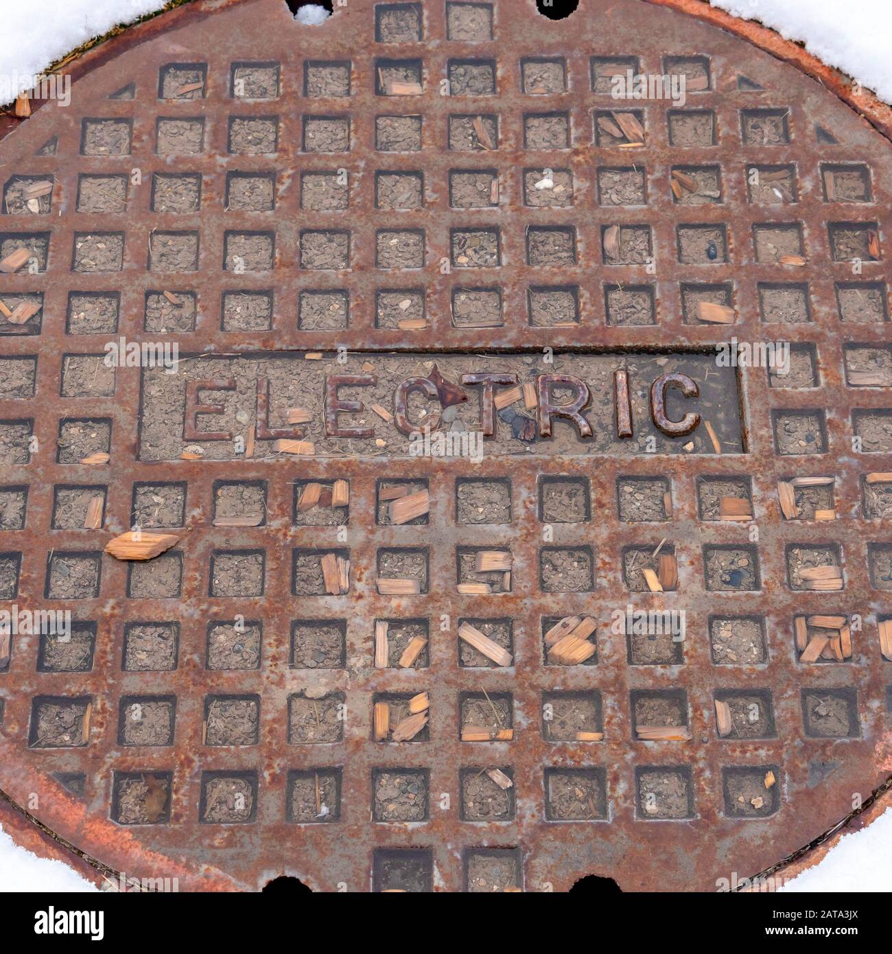 Square frame Rusty circular utility electric manhole cover amid fresh ...