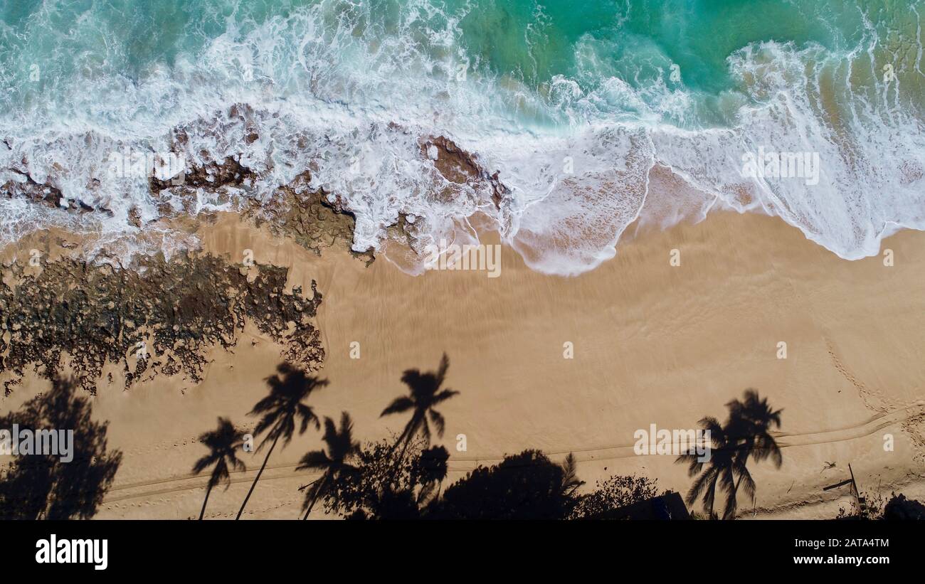 Aerial view of bright blue water and surf with waves crashing at Bonzai ...