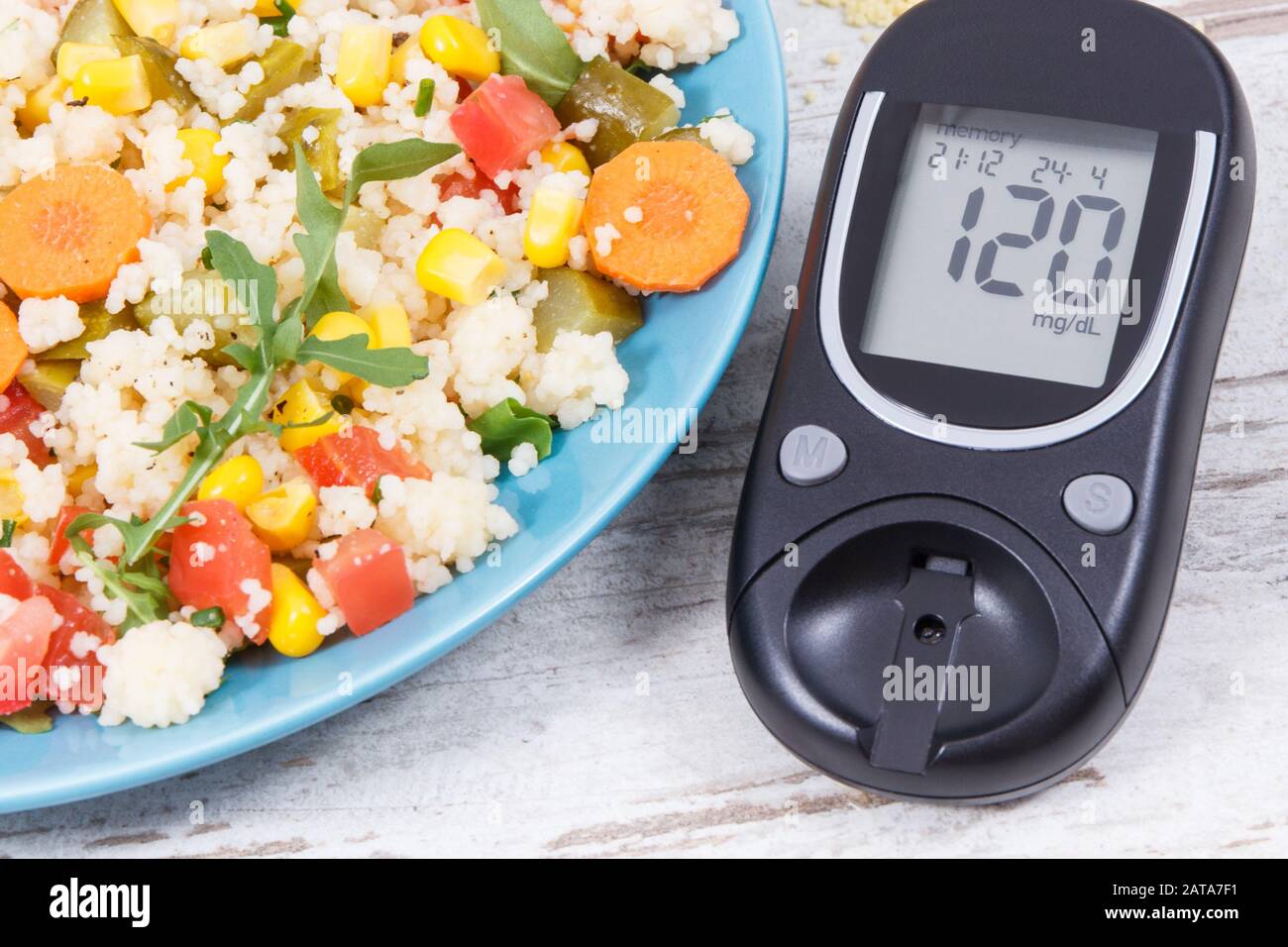 Glucometer for measuring sugar level and salad with couscous and ...