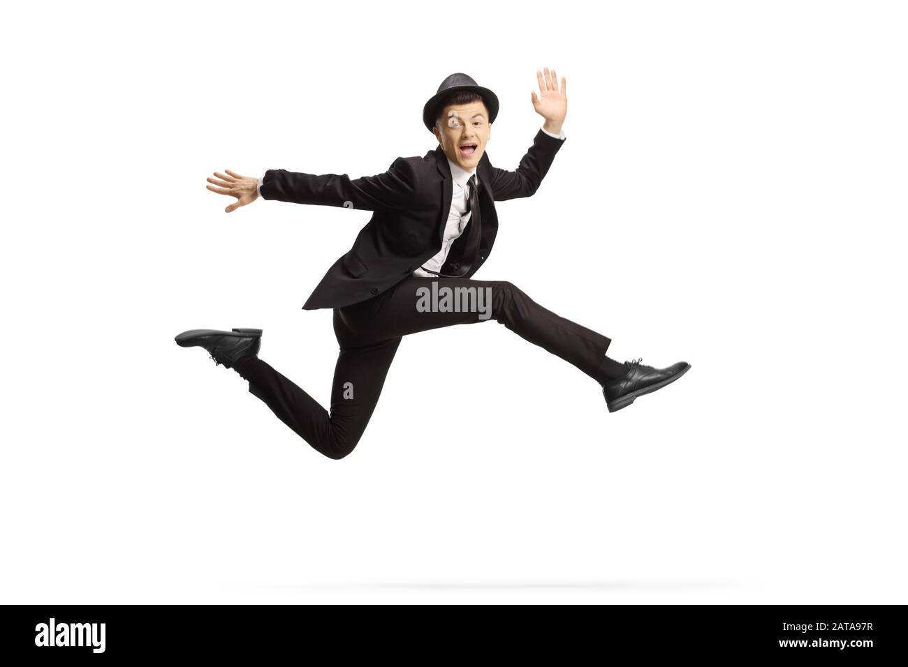 Young guy in a suit and top hat jumping high isolated on white ...