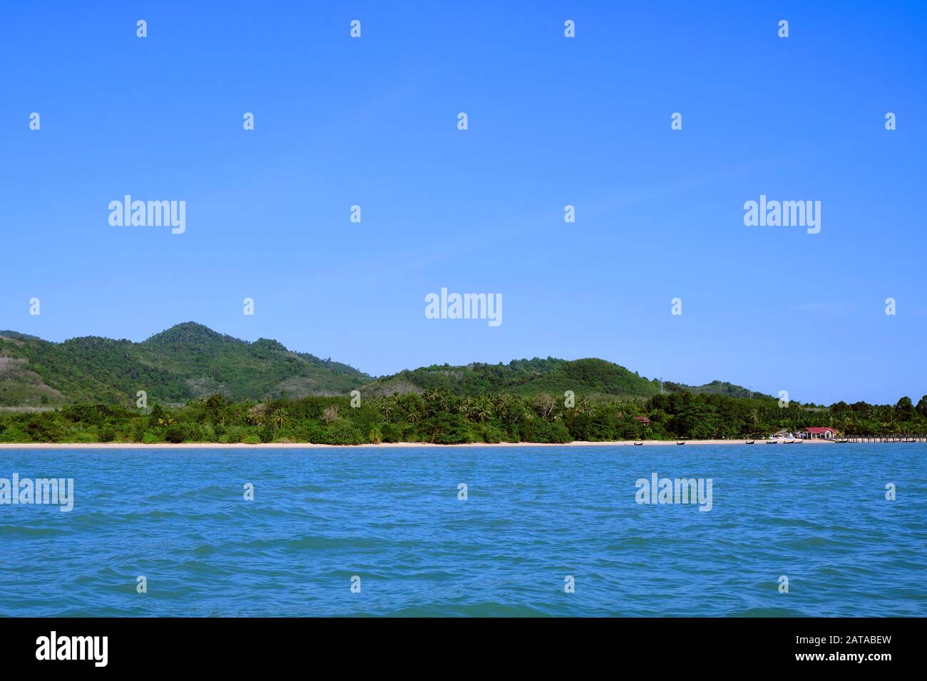 A shot of a beach in the distance over the water Stock Photo - Alamy