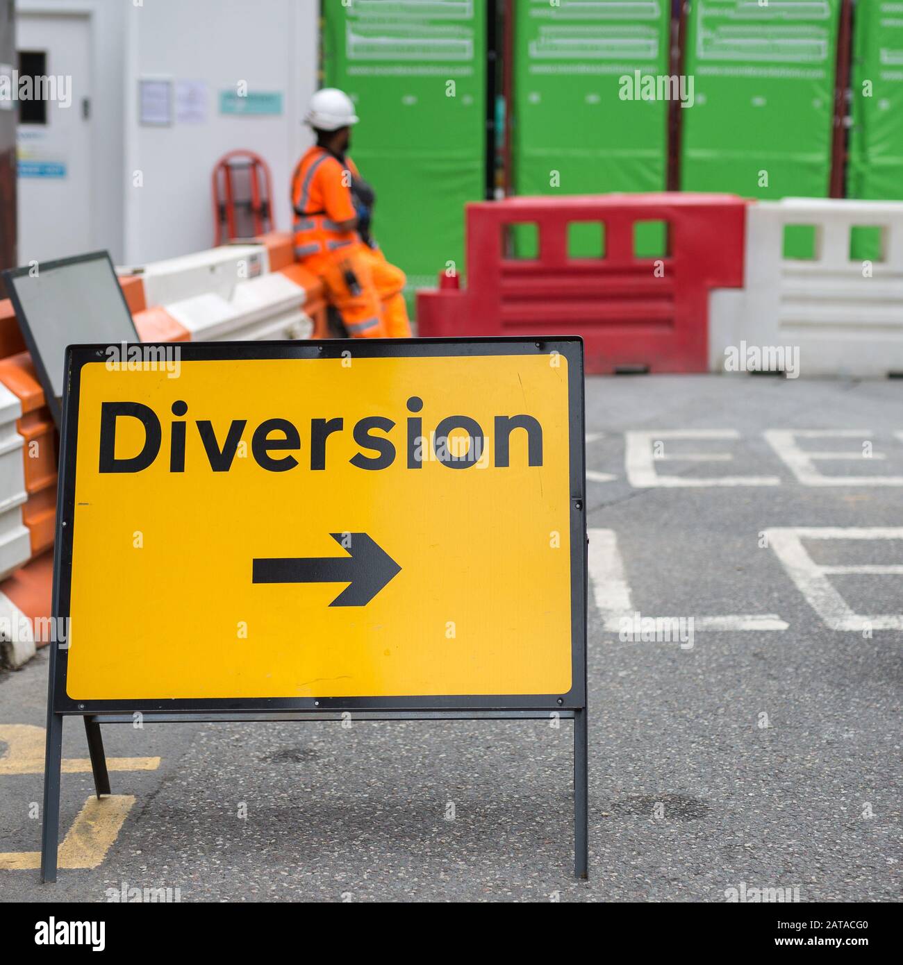 Yellow Road Sign with Arrow, Diversion: Barrier and Workers in ...
