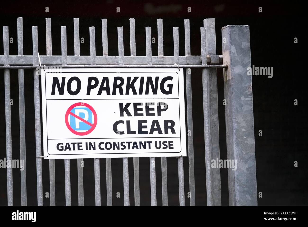 No parking keep clear sign with gate entrance door at constant use ...