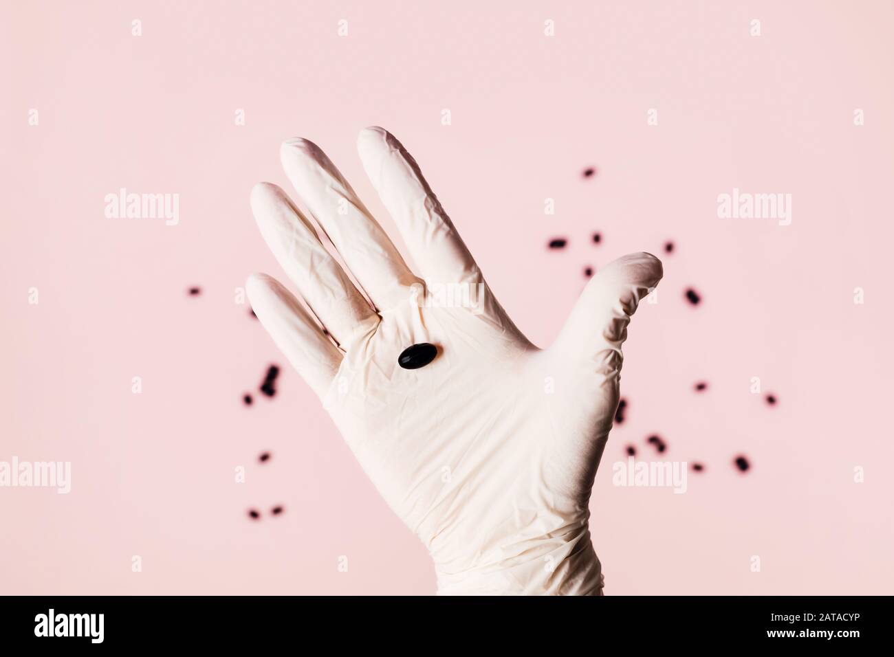 Hand in medical glove with tablets on pink background. Flat lay, top ...