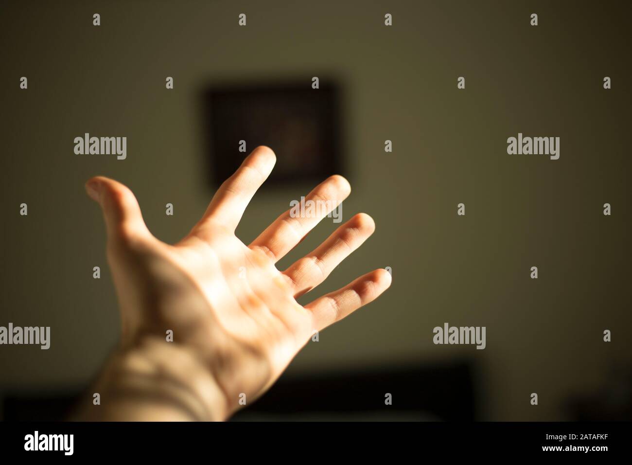 man extended his hand and holds the palm of his hand wide open as the ...