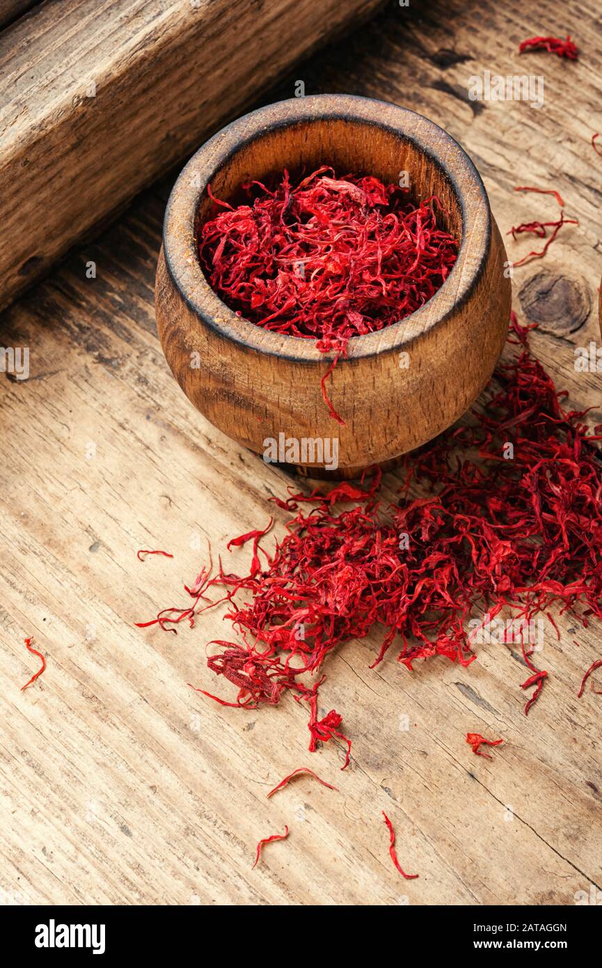 Raw organic red saffron spice on wooden background Stock Photo - Alamy