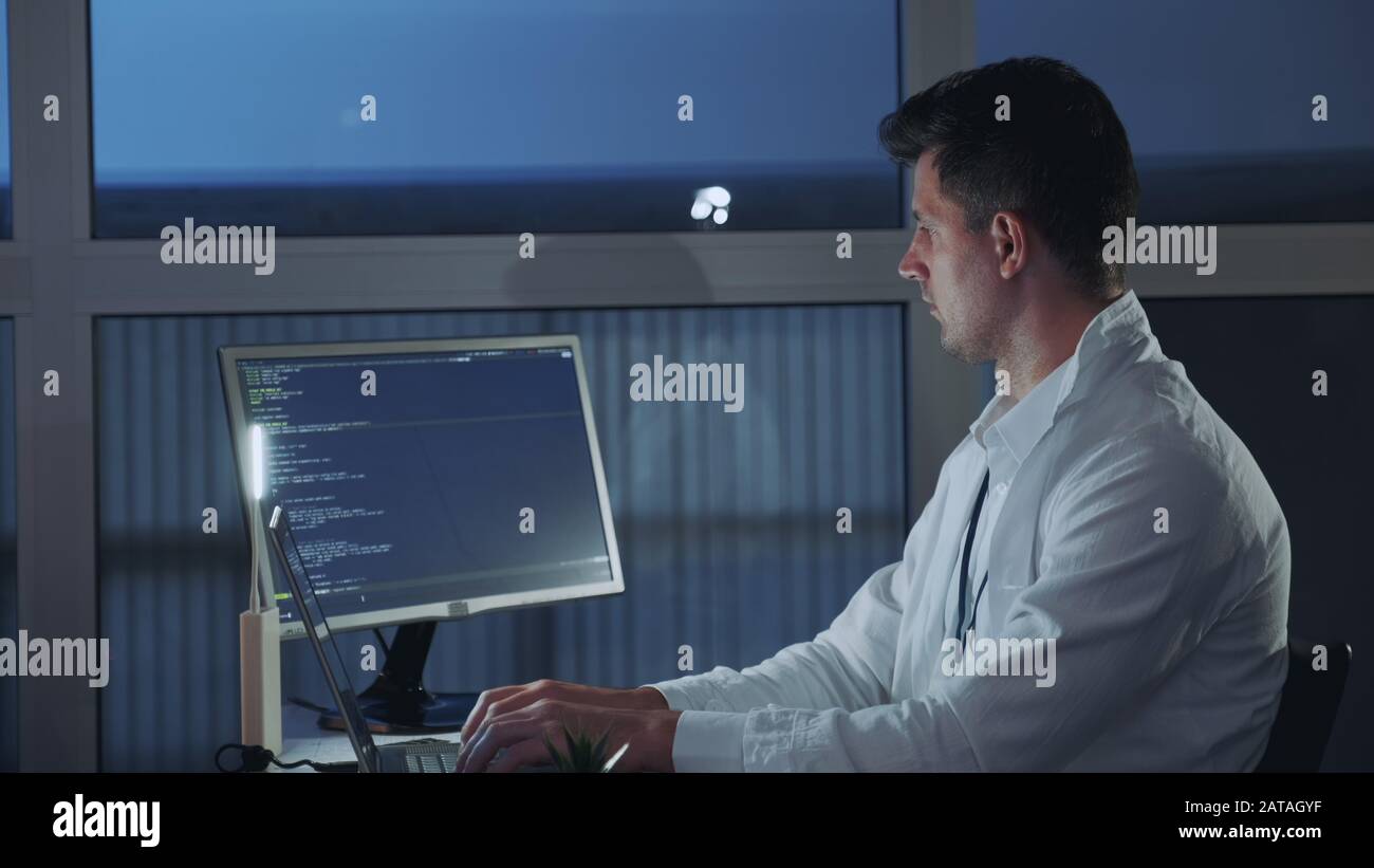 Side view of young electronics engineer being engaged in his research ...