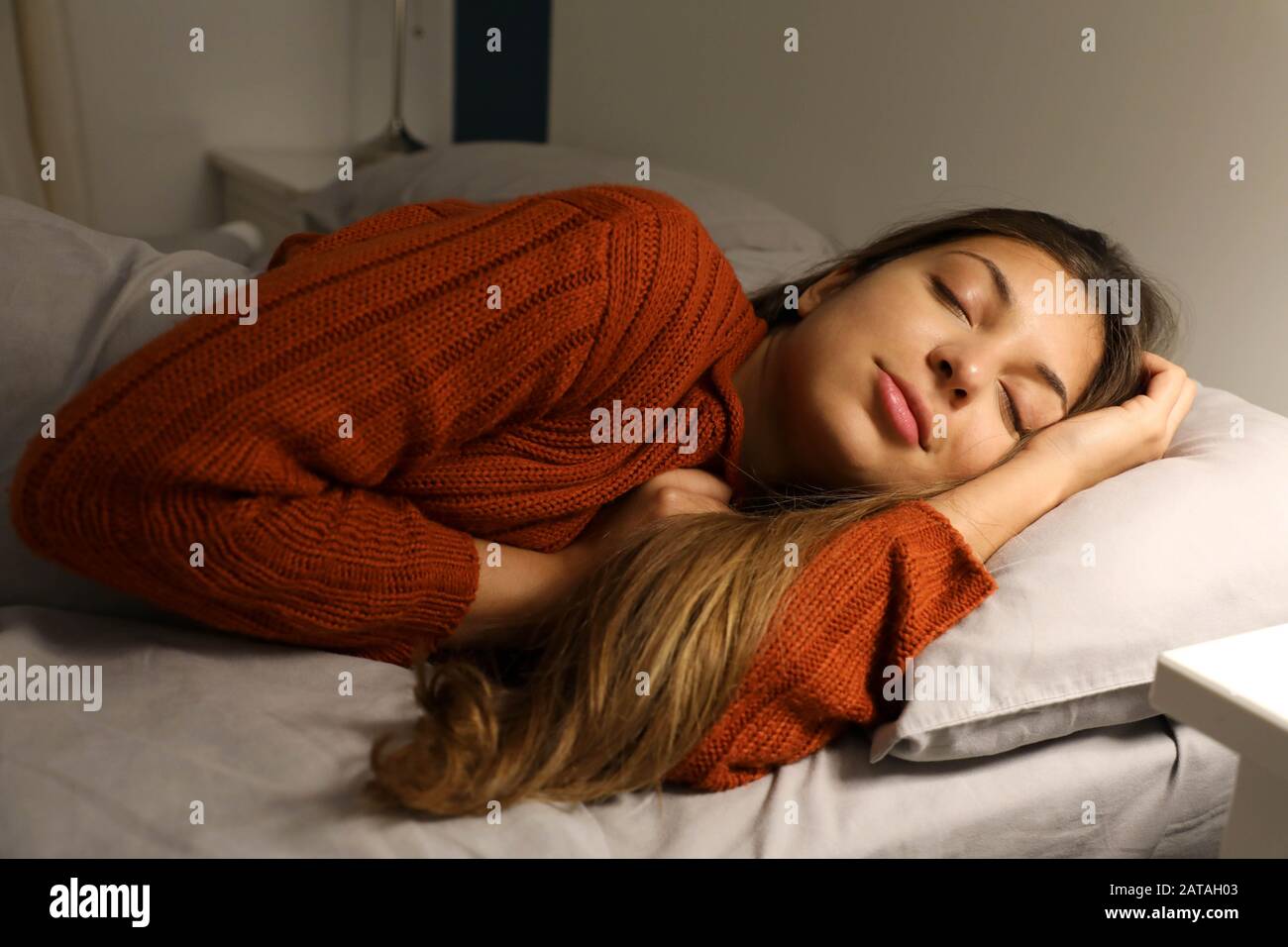 Relaxed young woman sleeping on bed at night Stock Photo - Alamy