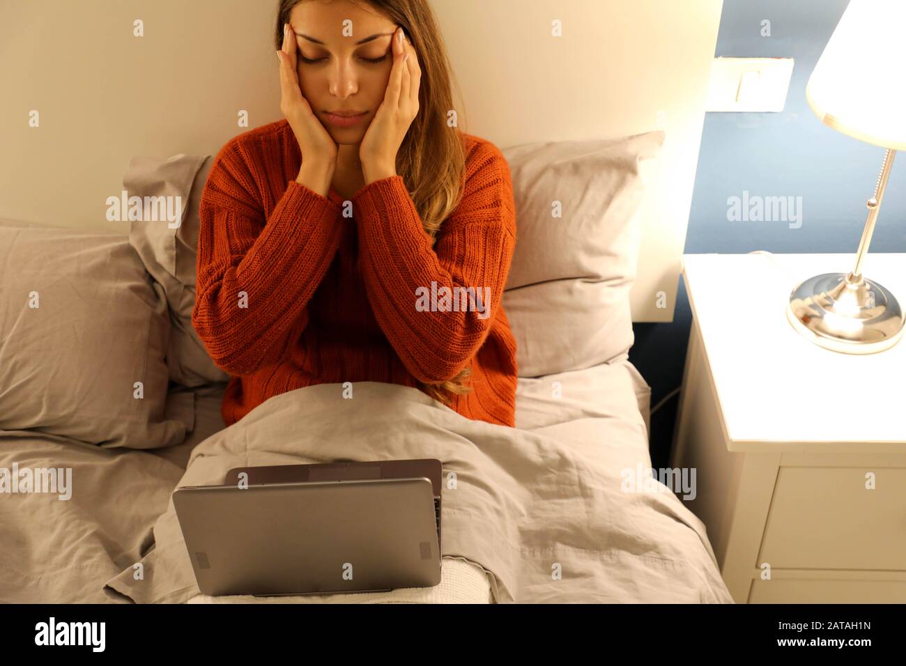 Young woman lying exhausted on bed in hotel room hi-res stock ...