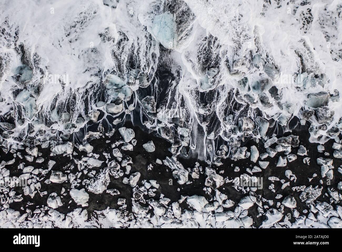 Aerial view of ice floes and icebergs on Diamond beach during sunset ...