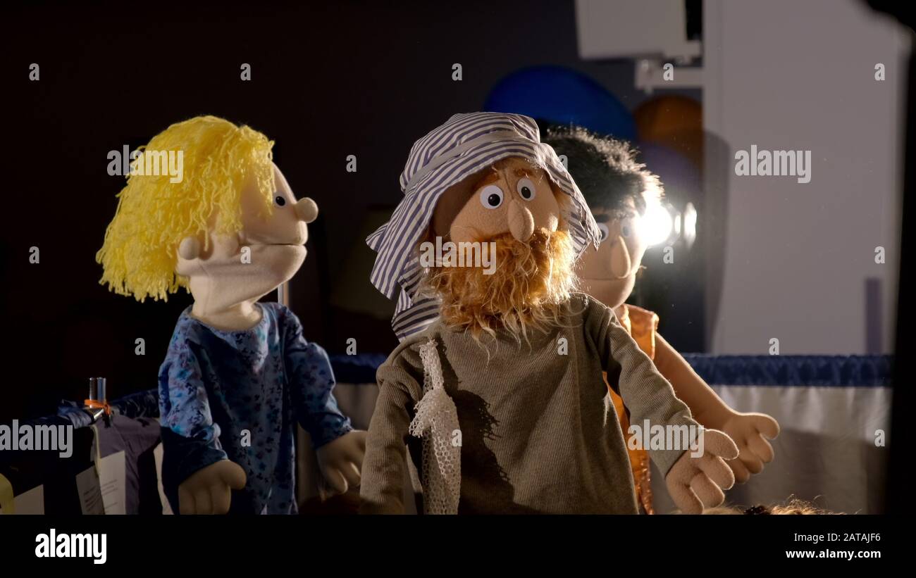 Three puppet dolls hiding under the scenes during the performance in ...