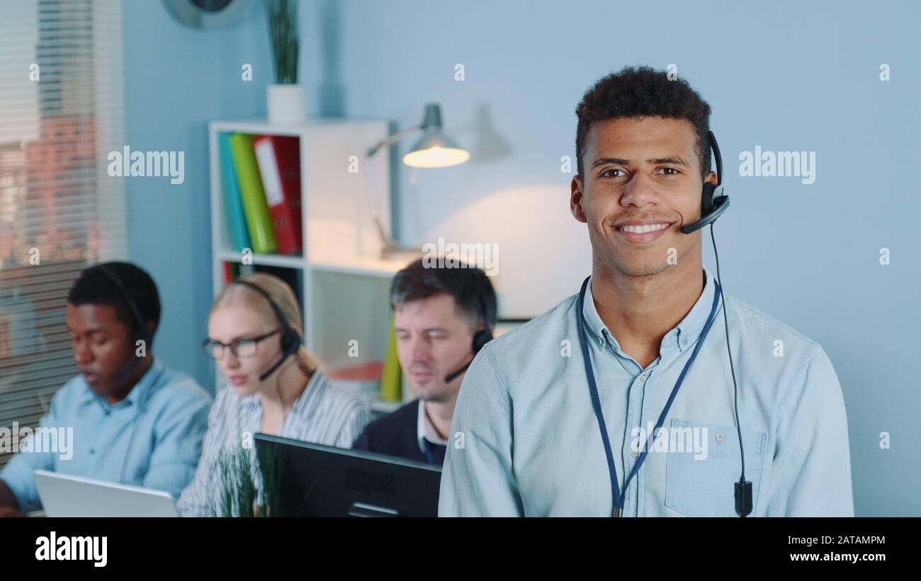 Portrait of multiracial customer service operator in headset smiling to ...