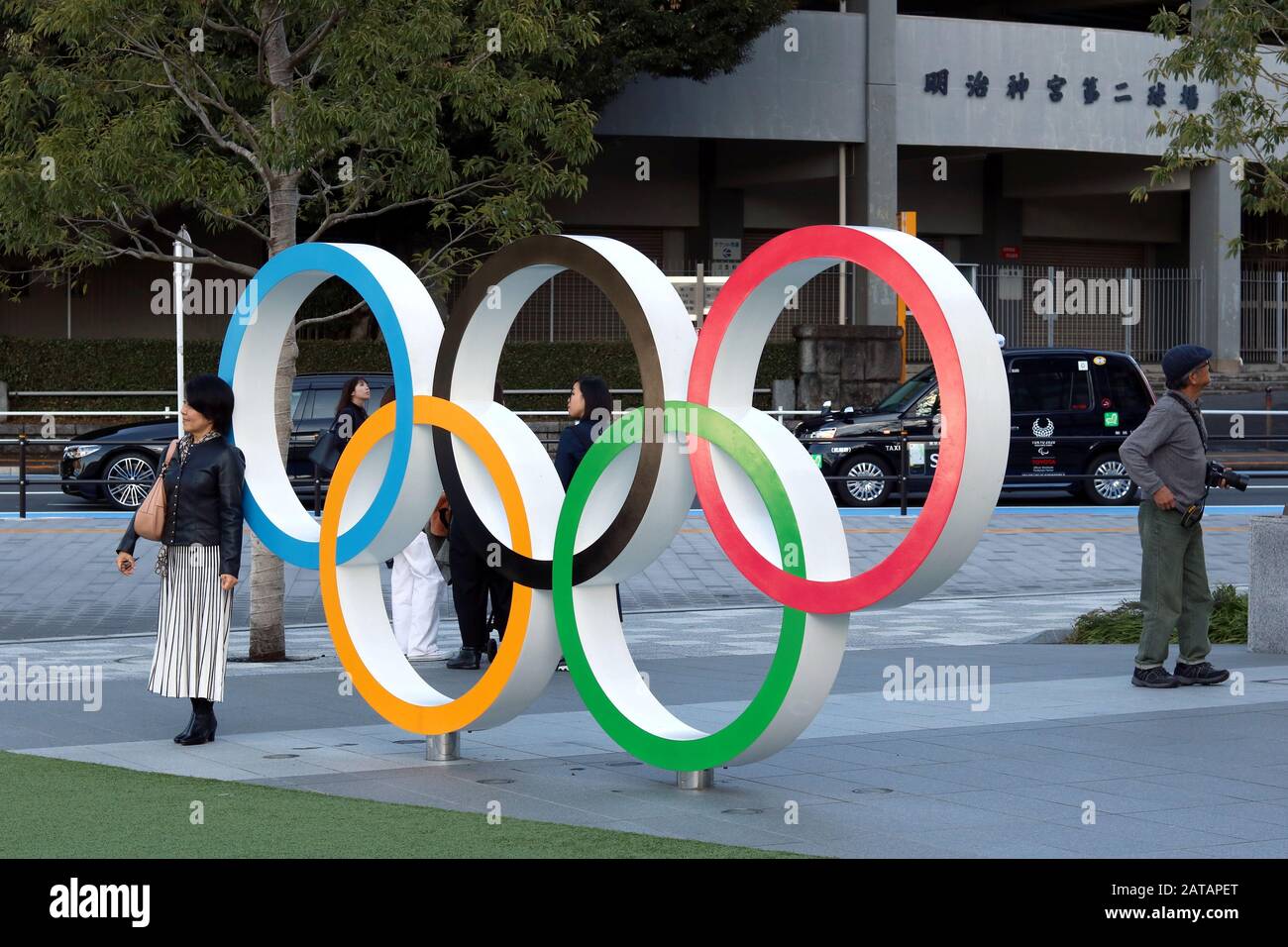 A visitors pose for a photograph with an Olympic Rings monument in the ...