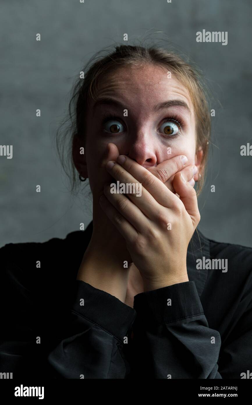 Young Woman Screaming with Hands Covering Mouth Stock Photo - Alamy