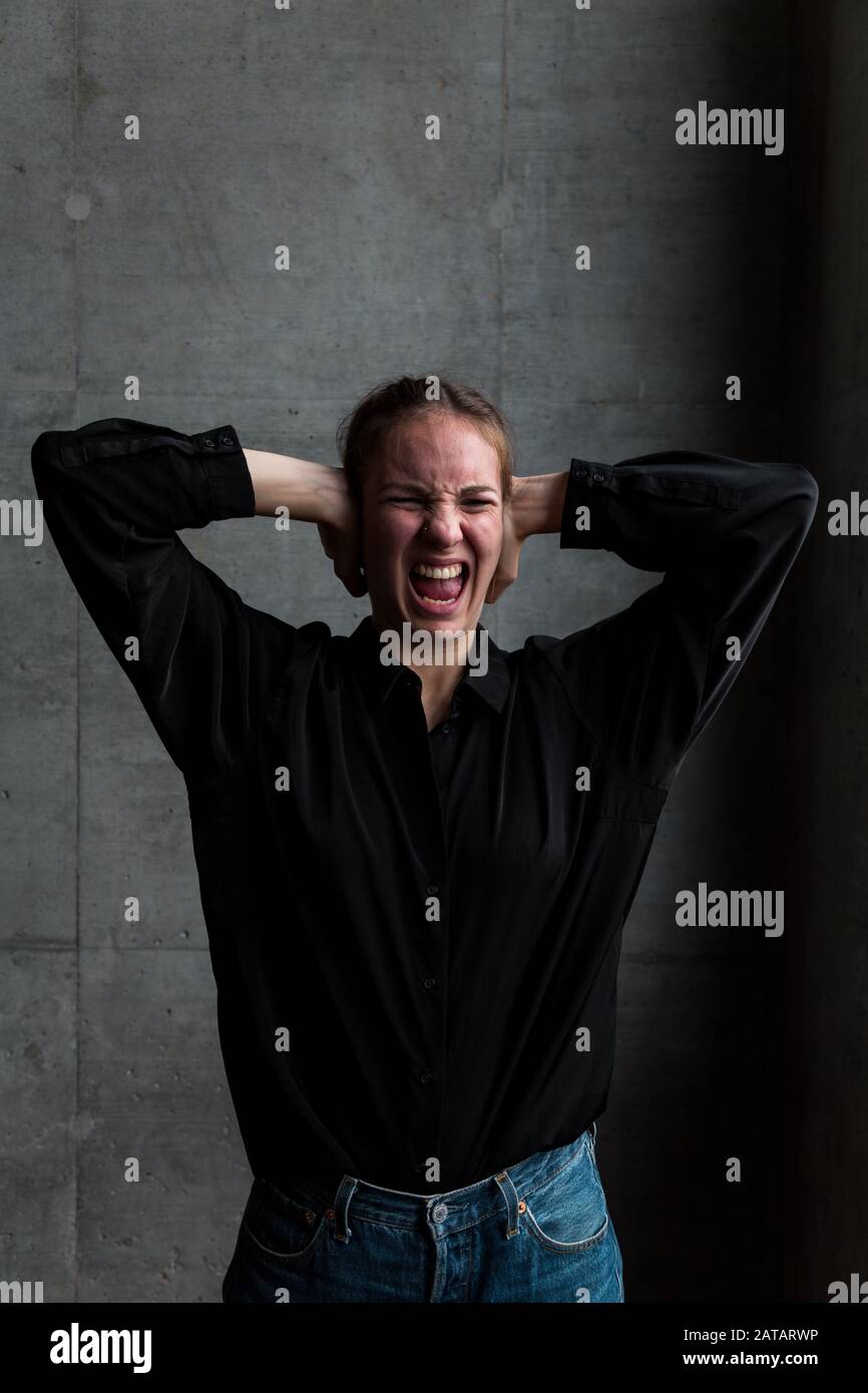 Young Woman with Hands Covering Ears Screaming Stock Photo - Alamy