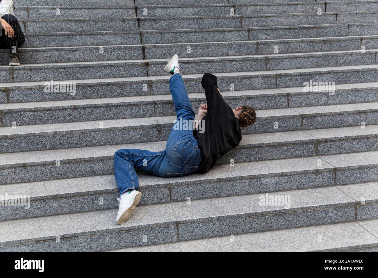 Woman Lying on Outdoor Steps with Leg Raised Stock Photo - Alamy