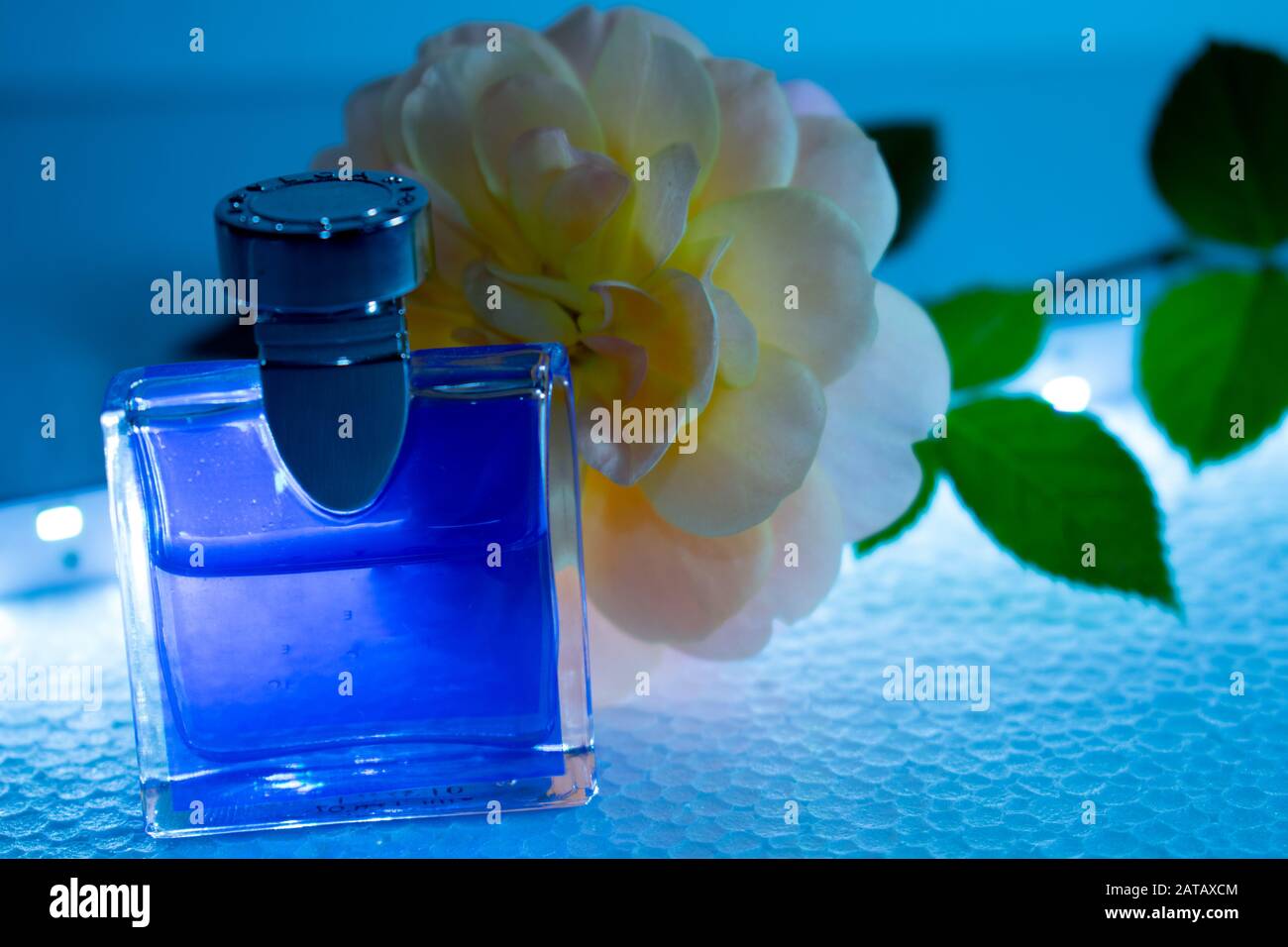blue perfume bottle and flower Stock Photo - Alamy