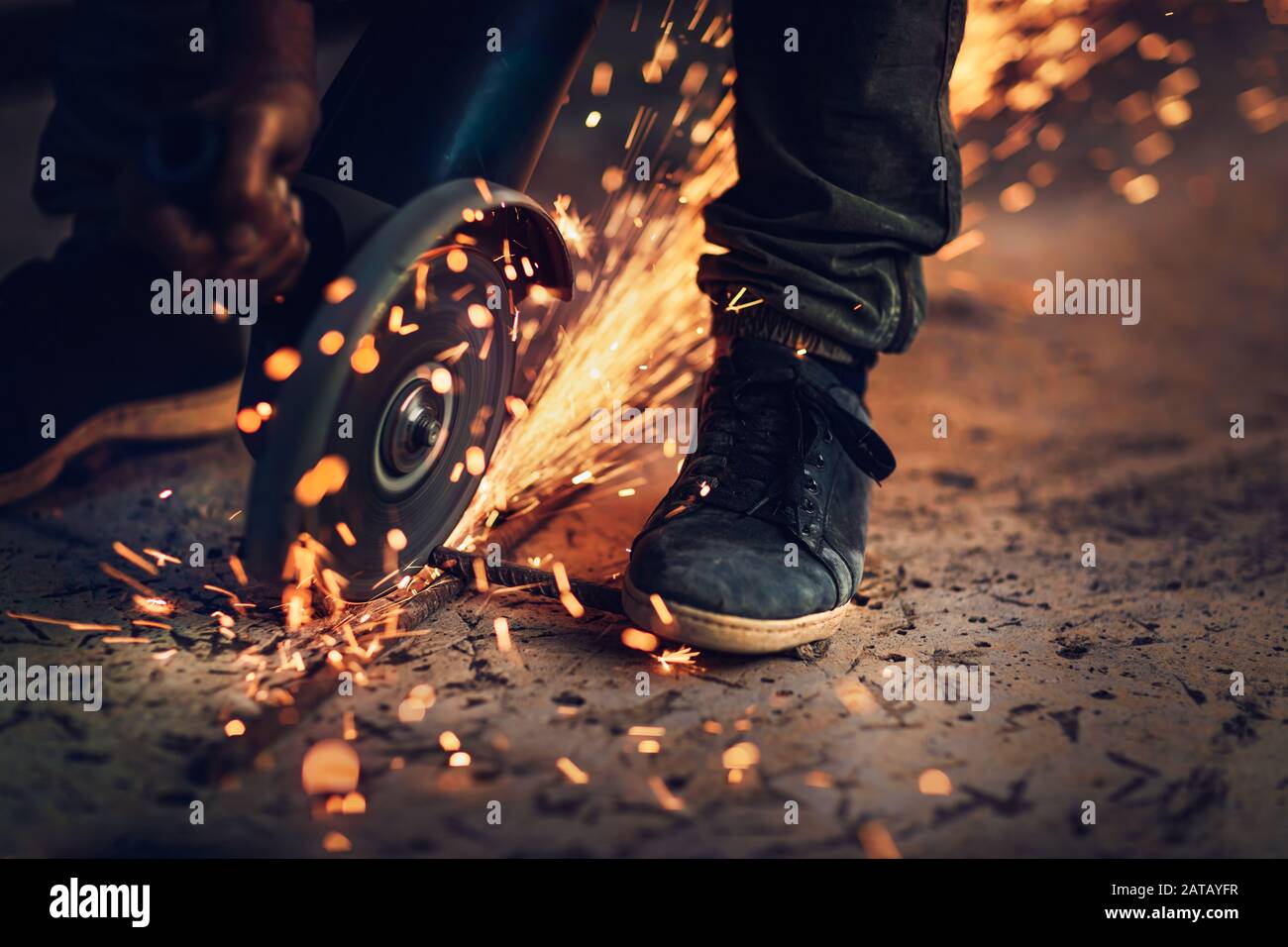 Welder at work, closeup photo of hot bright sparks fly out from under ...