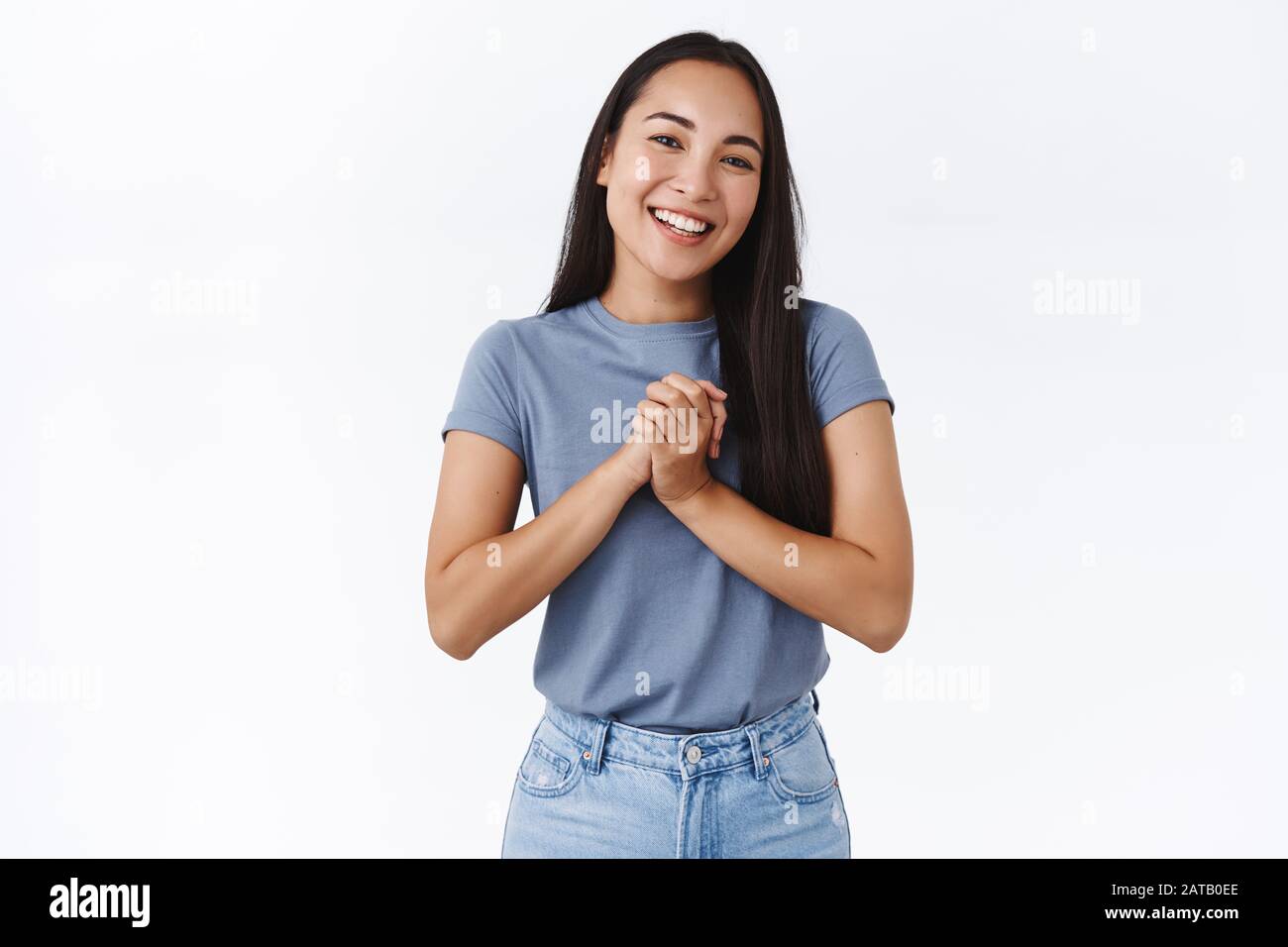 Happy, pleased charming asian woman clasp hands touched, receive help ...