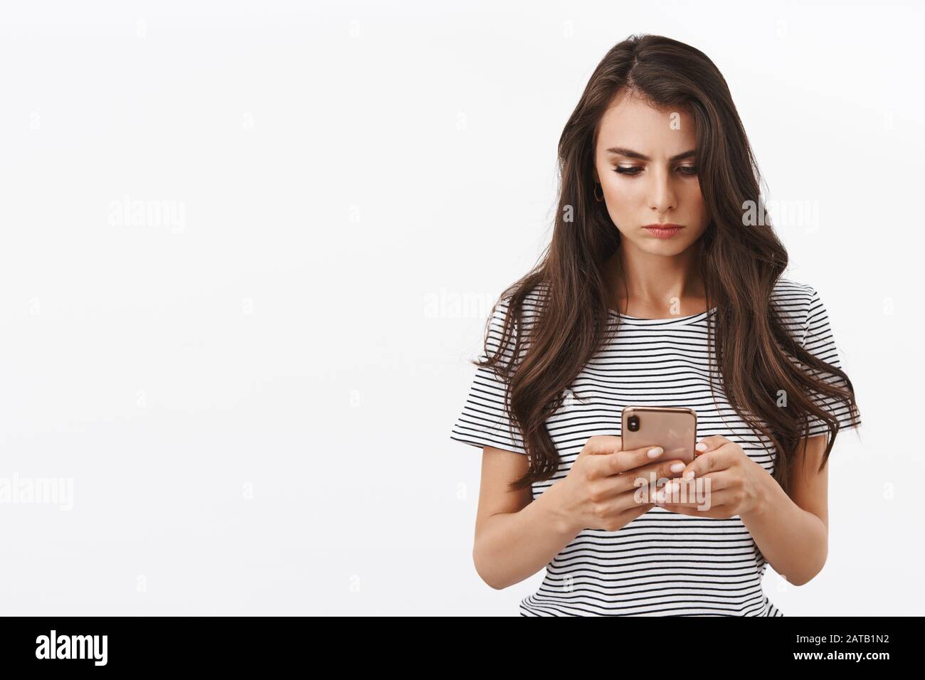 Serious-looking, concerned young woman receive disturbing message ...