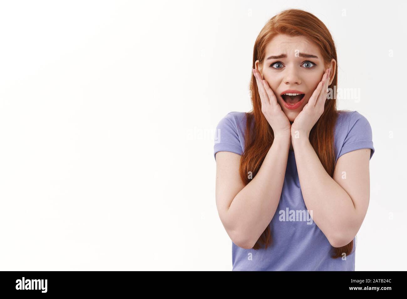 Scared, concerned alarmed silly redhead woman, looking terrified ...