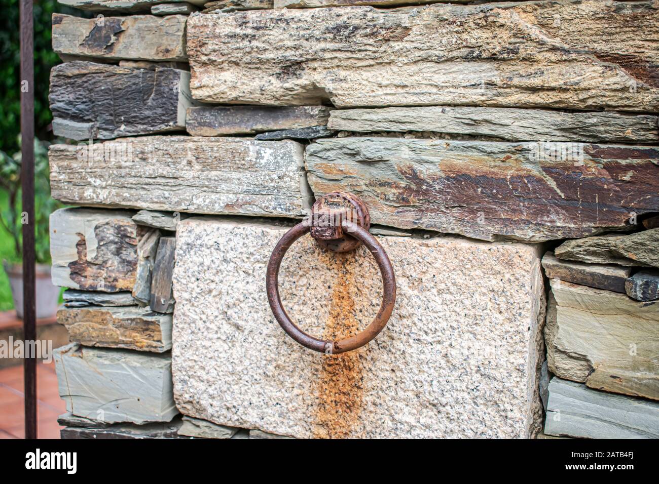 Ring made of wrought iron located on a stone wall with traces of rust ...