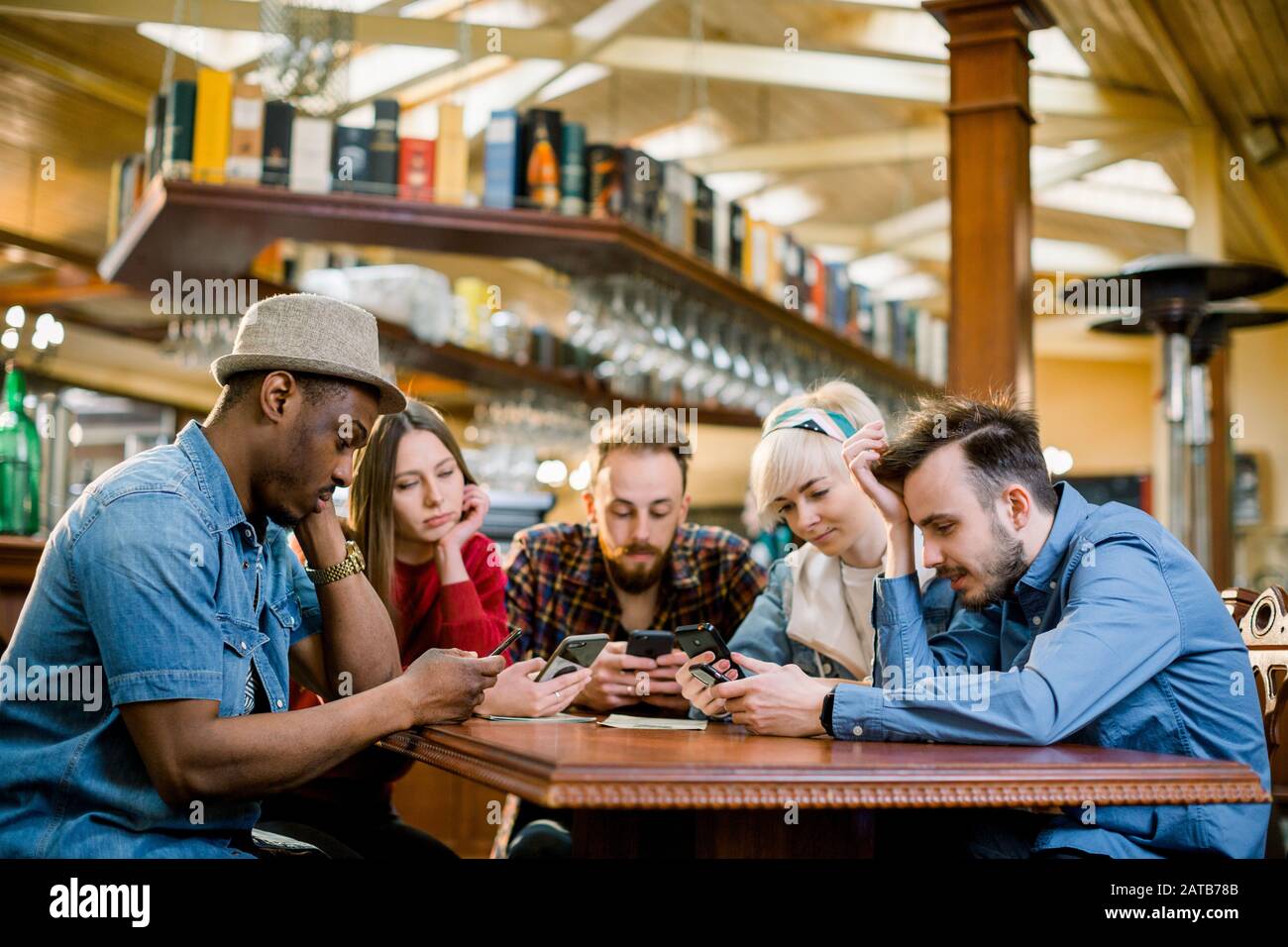 Young college students or coworkers using smartphones together at ...