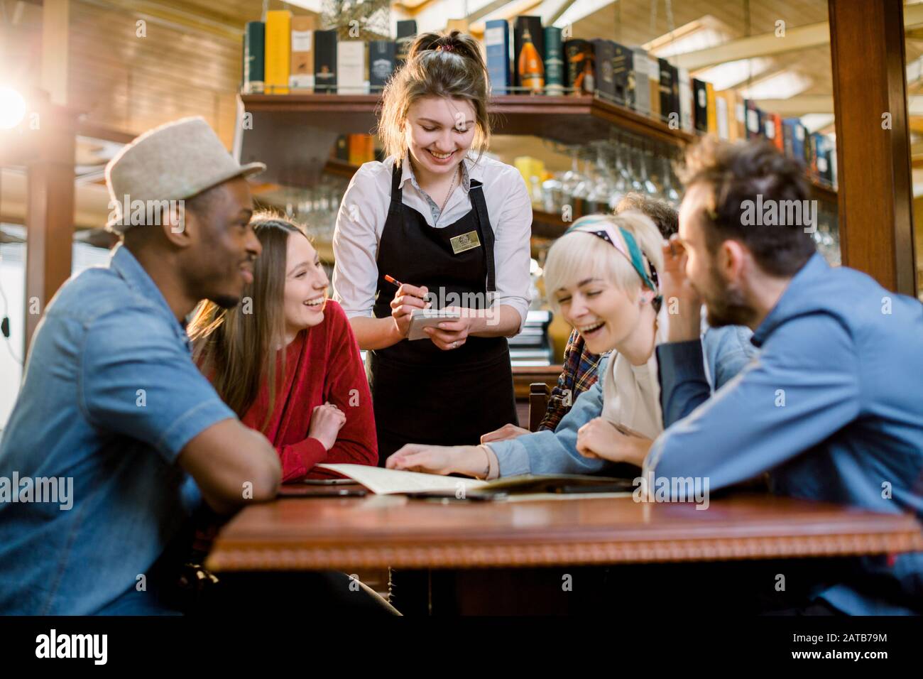 Waitress female welcoming diverse cafeteria pub guests making order ...